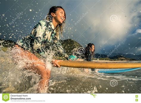 Girls With Surfboards In Splashing Wave On A Beach Stock Image Image
