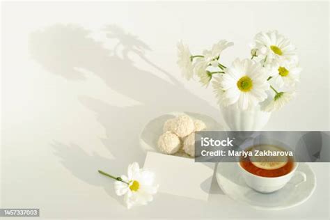 차와 꽃 레몬 과자 꽃다발 또는 카모마일 또는 데이지 꽃과 흰색 배경에 복사 공간이있는 빈 카드가있는 차 한잔 0명에 대한 스톡