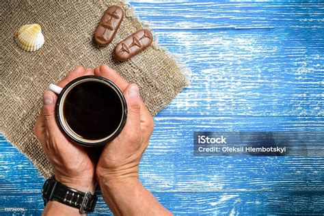 남자는 초콜릿 바와 향기로운 커피 한 잔을 보유 하 고 블루 세 렛 및 바닥에서 오래 된 천으로 디자인 나무 배경 0명에 대한 스톡 사진 및 기타 이미지 Istock