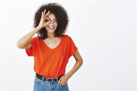 스튜디오에서 포즈 아프로 헤어 스타일으로 긍정적 인 여자 무료 사진