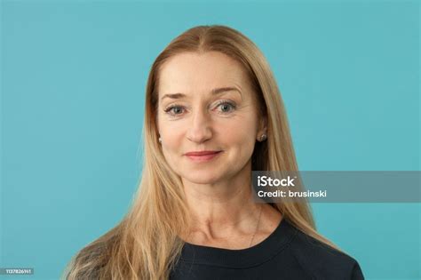 파란색 배경에 매력적인 55 년 오래 된 금발 여자의 스튜디오 초상화 여자에 대한 스톡 사진 및 기타 이미지 여자 유색 배경 한 명의 여자만 Istock