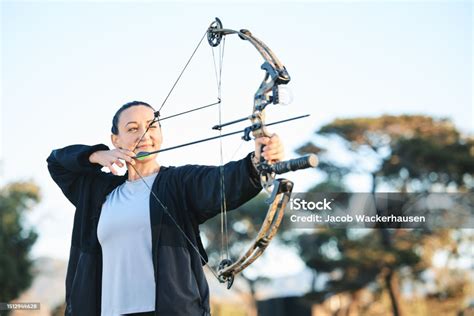 행복한 여자 활 또는 화살은 사냥 취미 또는 운동에서 스포츠 분야 사격장 또는 게임 자연을 겨냥합니다 양궁 사람 또는 운동 선수는 표적 훈련 경쟁 또는 연습에서 무기로