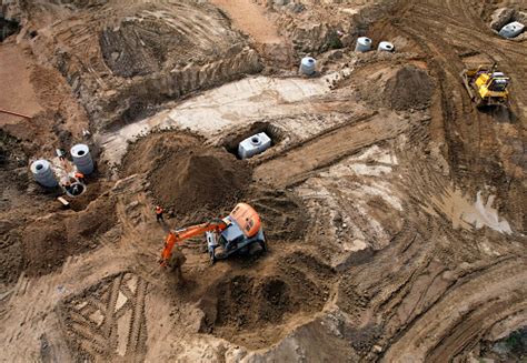 건설 현장에 콘크리트 우물 반지와 하수도 파이프를 배치 폭풍 하수구의 설치 중 지구 공사 위생 하수구 하수도 건설을 위한 발굴 하수 배수 및 콘크리트 파이프 개발에 대한