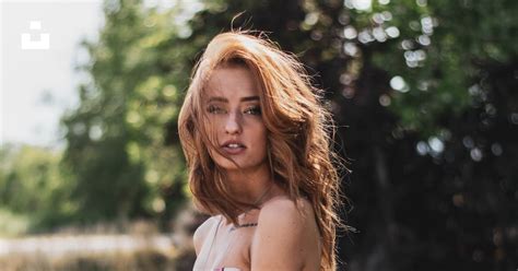 흰색과 빨간색 꽃무늬 탱크 탑과 푸른 데님 청바지를 입은 여자 푸른 잔디에 서 있다 사진 Unsplash의 무료 콜로라도 이미지