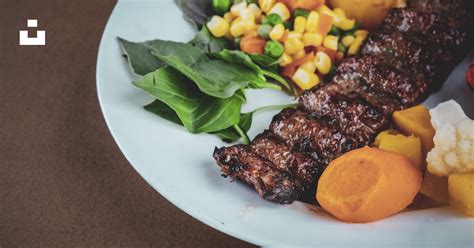 흰색 세라믹 접시에 녹색 야채를 곁들인 구운 고기 사진 Unsplash의 무료 식물 이미지