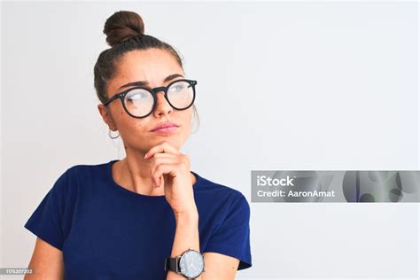 질문에 대해 생각 하는 고립 된 흰색 배경 심각한 얼굴 위에 파란색 티셔츠와 안경을 입고 빵과 아름 다운 여자 매우 혼란 스러운 생각 T 셔츠에 대한 스톡 사진 및 기타