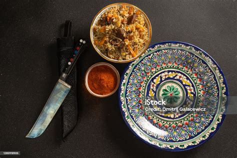 필라프는 우즈베키스탄 의 전통 요리로 양고기나 쇠고기 채소를 곁들인 전통 쌀 요리입니다 전통적인 우즈베키스탄 패턴과 향신료가 있는 부엌 칼 0명에 대한 스톡 사진 및 기타