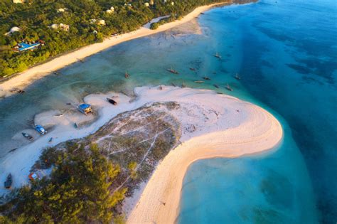 일몰에 모래 해변과 열대 바다 해안에 낚시 보트의 공중 보기 인도양 잔지바르 아프리카의 여름 휴가 보트 녹색 나무 투명 한 푸른 물 풍경입니다 맨 위 보기 0명에 대한 스톡