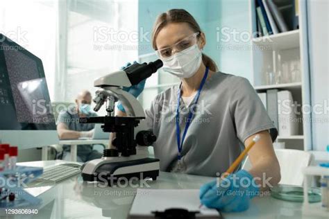 현미경으로 작업하는 동안 문서에 메모를 만드는 여성 실험실 노동자 과학자에 대한 스톡 사진 및 기타 이미지 과학자 캔디드 생물학 Istock