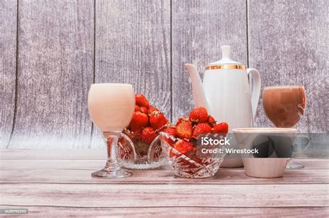 나무 테이블에는 잘 익은 딸기 주전자와 머그잔 칵테일이 들어간 와인 잔이있는 두 개의 화병이 있습니다 딸기에 대한 스톡 사진 및 기타 이미지 Istock