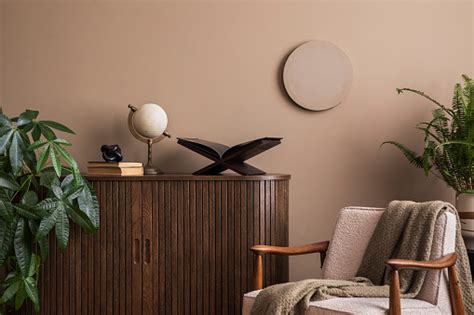 모형 포스터 프레임 나무 찬장 둥근 커피 테이블 검은 사다리 공 무늬가 있는 카펫 둥근 베개 및 개인 액세서리가 있는 아늑한 거실의 인테리어 디자인 가정 장식 템플렛 0명에