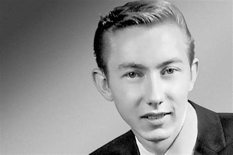 A Black And White Photo Of A Young Man In A Suit With A Tie On