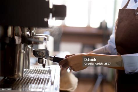 카페에서 커피를 만들기 위해 으깬 동안 커피 그라인더 가루를 들고 있는 젊은 아시아 여성의 손을 클로즈업하고 블랙 커피를 만들기