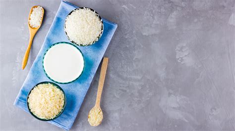 회색 배경에 쌀 우유와 쌀 씨앗 파란 냅킨에 유리에 쌀 우유 시멘트 배경에 비건 비 유제품 우유 상승에서 대체 우유 Minimalism 복사 공간 0명에 대한 스톡 사진 및