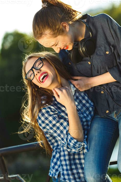 Two Playful Girls Having Fun Outdoors At Sunset Light 23271719 Stock
