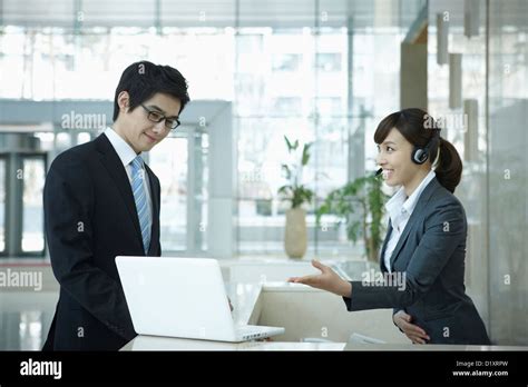 A Help Desk Woman Explaining To Businessman Through Laptop Stock Photo Alamy