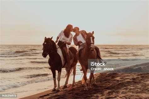 해질녘에 모래 사장에서 말을 타는 여름 옷을 입은 사랑하는 부부 배경에 바다와 일몰 선택적 초점 30 34세에 대한 스톡 사진 및 기타 이미지 Istock