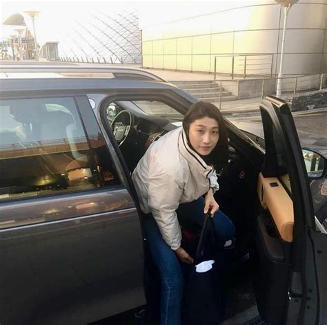 A Woman Is Getting Out Of Her Car And Holding Onto The Door Handle With Luggage