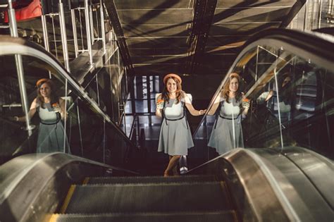 에스컬레이터에서 공항에서 모자를 쓰고 웃는 모습 기내 수하물을 가지고 여행하는 사람들 테마 관광 및 교통 에스컬레이터에 공항 터미널에서 커피와 백인 소녀 공항에 대한 스톡