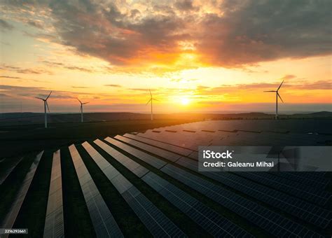 녹색 에너지 전기를 생산하는 풍차 터빈 공중 뷰 친환경 에너지는 탄소 배출량을 줄이고 지구를 더 깨끗하고 친환경적으로 만듭니다 태양 전지판은 일몰 시 공원과 풍력 터빈을