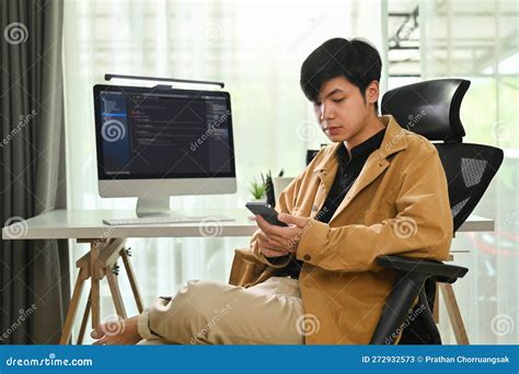 portrait of male programmer sitting in front of computer monitor with