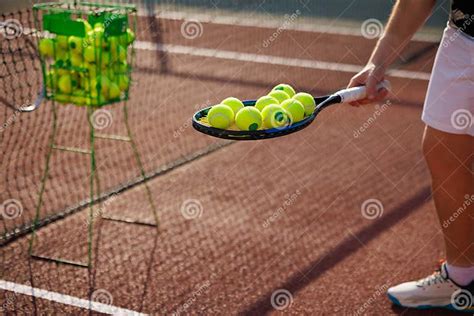 tennis player collecting balls on tennis court close up after training