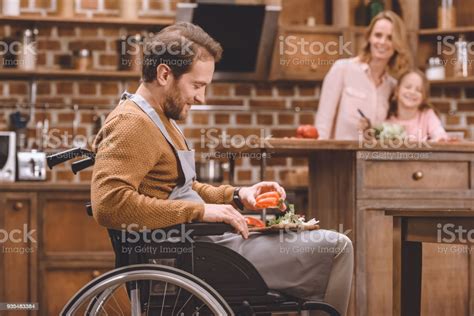 행복 한 엄마와 딸의 뒤에 서 있는 동안 샐러드 휠체어 절단 야채에서 사람이 미소의 측면 보기 휠체어에 대한 스톡 사진 및 기타 이미지 Istock