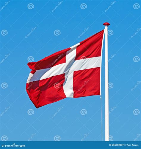 The Danish Flag The Danish Flag Blowing Against A Blue Background