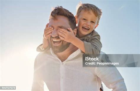 아빠 아이 돼지는 게임을 위해 눈을 가리고 놀고 사랑으로 햇빛 속에서 즐거운 시간을 보냅니다 태양 하늘 유대감이 있는 가족 아버지와 아이는 웃으면서 야외에서 함께 만화와