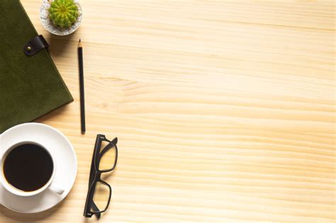 노트북 스마트폰 및 기타 작업 용품이 있는 목재 책상 사무실과 커피 한 잔 텍스트를 입력할 수 있는 복사 공간이 있는 평면도입니다 평평한 위치에 있는 책상 테이블의 디자이너