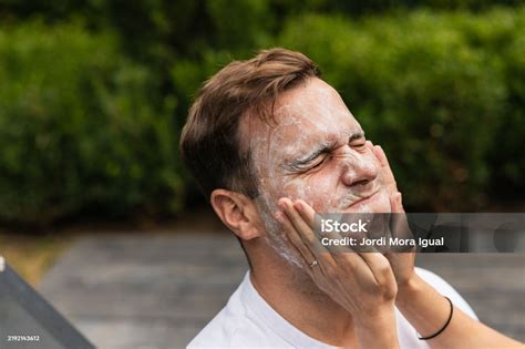 Woman Applying Exfoliating Sunscreen Foam On Mans Face Outdoors Stock
