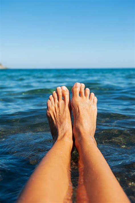Relaxing Barefoot By The Serene Seaside Surrounded By Calm Blue Waves