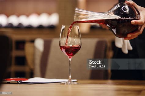 전문 여성 소믈리에가 디켄터에서 유리에 레드 와인을 붓고 이미지를 닫습니다 와인 가게의 지하실에 알코올 음료를 따르는 여성 웨이터 디캔터에 대한 스톡 사진 및 기타 이미지