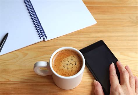 여자의 손을 잡고 핸드폰 노트북와 펜 작업에 뜨거운 커피 한 잔 옆에 책상 갈색에 대한 스톡 사진 및 기타 이미지 갈색