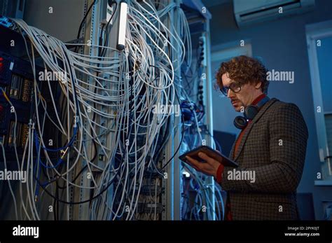 Male It Technical Specialist Makes A Diagnosis In Server Room Stock