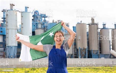교외 공장 근처에서 작업복을 입은 쾌활한 여성 노동자가 서서 파키스탄 국기를 손에 들고 있다 20 24세에 대한 스톡 사진 및 기타 이미지 Istock
