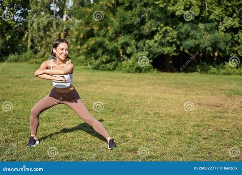 Young Asian Fitness Girl Stretching Workout In Park Showing Exercises