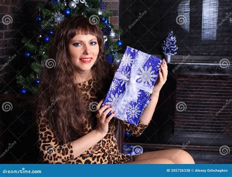 Beautiful Legged Redhead Model In Minidress And Stockings Posing At Christmas Tree Stock Photo