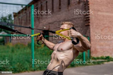 남자 선수는 우수한 교육 도시 여름 교육 훈련 루프 강도 및 균형 동기 부여 무두 질된 피부 느낌 가슴의 근육의 운동입니다 화창한 날입니다 남자의 체력입니다 교차 훈련법에