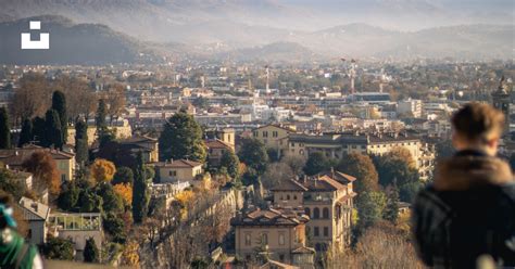 도시가 내려다 보이는 벽에 앉아있는 사람 사진 Unsplash의 무료 초상 이미지