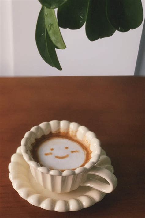 갈색 거품 거품 예술 고요한 깨지다 나뭇잎 단순한 즐거움 도기 도자기 컵 디자인 따뜻한 따뜻한 음료 라떼 라떼 아트 모닝 커피 목조 테이블 미소