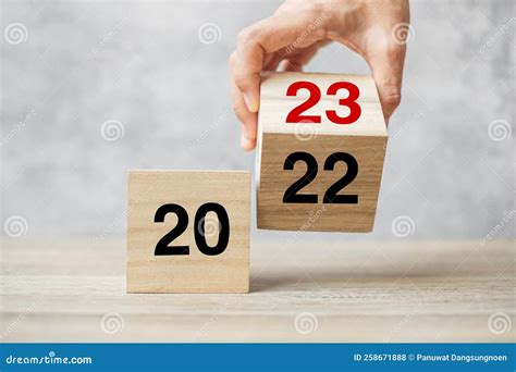 hand flipping block 2022 to 2023 text on table resolution strategy plan goal motivation