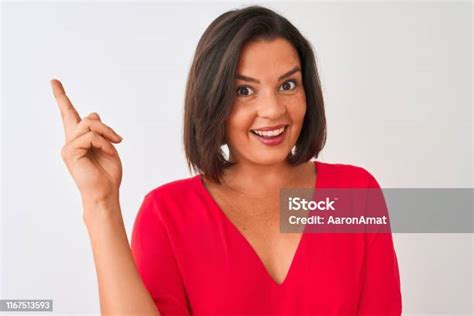 고립 된 흰색 배경 위에 서있는 빨간 티셔츠를 입은 젊은 아름다운 여성은 측면에 손과 손가락으로 가리키는 매우 행복합니다 T 셔츠에 대한 스톡 사진 및 기타 이미지 Istock