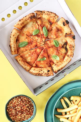 골판지 테이크아웃 피자 상자에 얇게 썬 피자 마르게리타 녹인 황금 버팔로 모짜렐라 치즈와 진한 토마토 마리나라 소스 토핑 감자