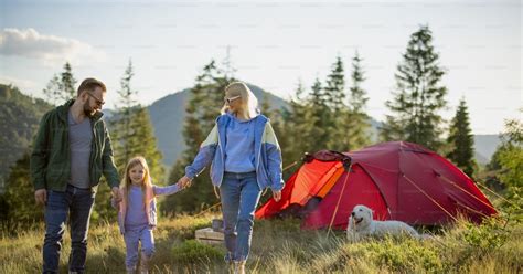 어린 소녀와 함께 젊은 백인 가족은 산에서 텐트를 가지고 여행하는 동안 푸른 초원에서 함께 걷습니다 캠프장에서 행복한 가족 여름 휴가 사진 Unsplash의 우크라이나 이미지
