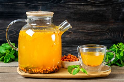 주전자와 나무 테이블에 민트와 꿀을 곁들인 맛있고 향기로운 바다 갈매 나무 속 차 의 컵 유용항염증 제 및 항스트레스 효과가 겨울 뜨거운 비타민 음료 개념 씨벅턴에 대한