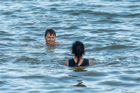 Premium Photo Young Guy And Girl Swim In The Lake