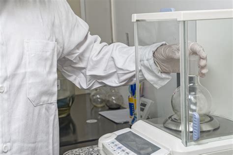 실험실 코트에서 생화학 과학자 또는 의사의 실험실 연구 및 실험실에서 작업 하는 유리 장비에 시약의 사용으로 테스트 튜브를 들고 N95 마스크 0명에 대한 스톡 사진 및