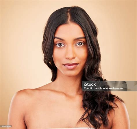 머리 관리 곱슬머리 스튜디오에 있는 여성의 얼굴은 갈색 배경에 고립되어 있다 뷰티 헤어스타일 천연 화장품 건강 웰빙 및 피부를 위한 살롱 트리트먼트에서 진지한 인도 모델의