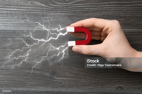 나무 배경에 번개가 달린 말굽 자석을 들고 있는 여자 평면도 텍스트를 위한 공간 강철에 대한 스톡 사진 및 기타 이미지 강철 과학 과학 실험 Istock